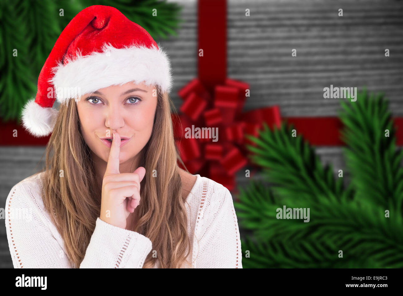 Composite image of festive blonde keeping a secret Stock Photo - Alamy