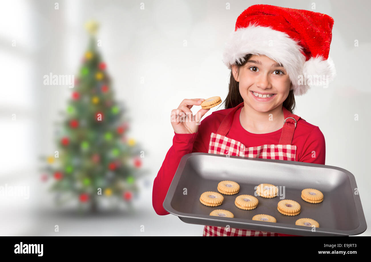 Composite image of festive little girl offering cookies Stock Photo - Alamy