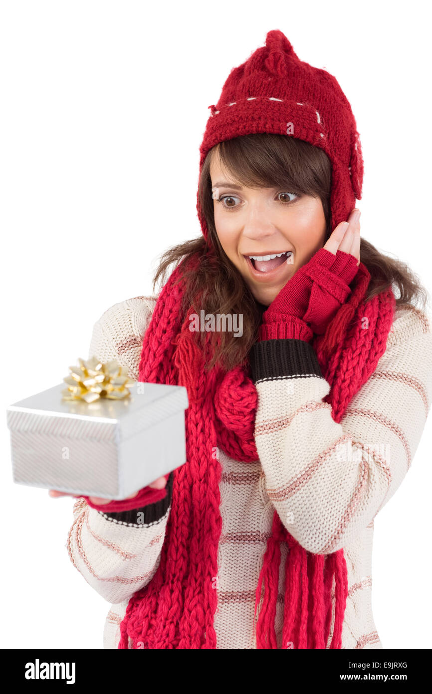 Surprised young woman holding a wrapped gift Stock Photo - Alamy