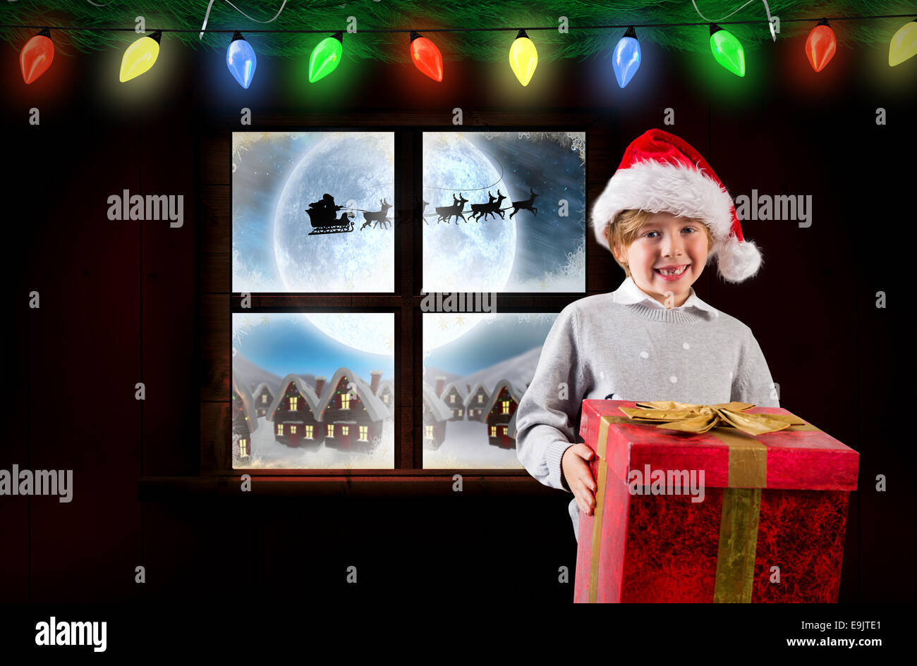 Composite image of festive boy holding gift Stock Photo - Alamy