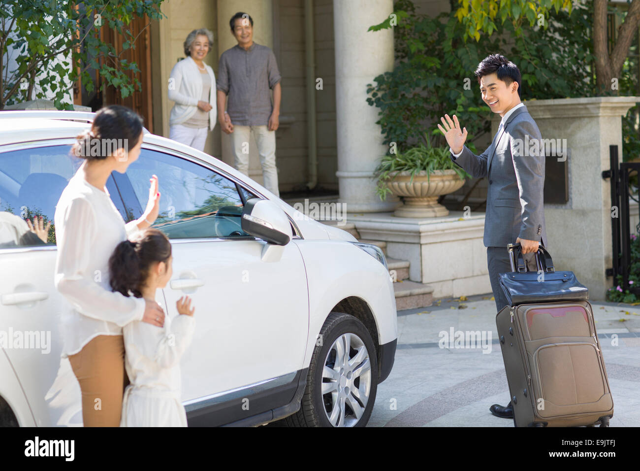 Mother and daughter waving goodbye to father Stock Photo - Alamy