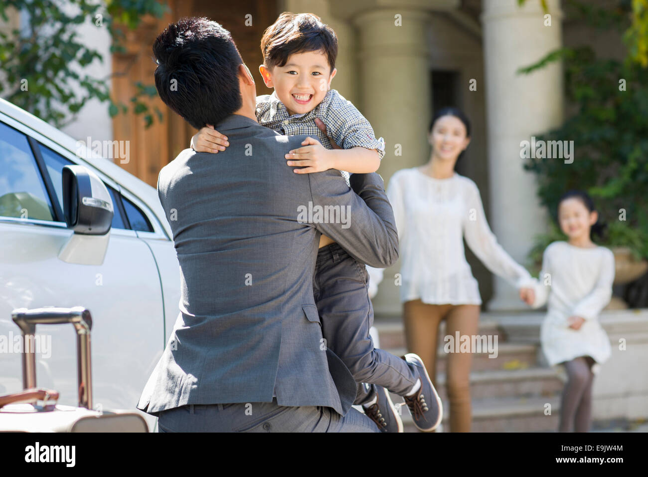Son greeting returning father Stock Photo - Alamy