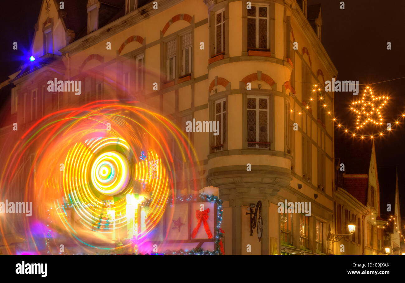 Street nicely illuminated with a colorful carousel in motion during the ...