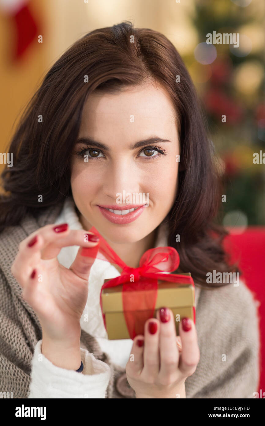 Smiling brunette opening a gift on christmas day Stock Photo - Alamy