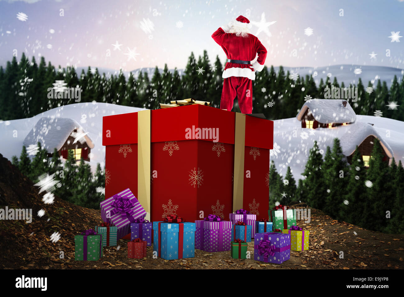 Composite image of santa standing on giant present Stock Photo - Alamy