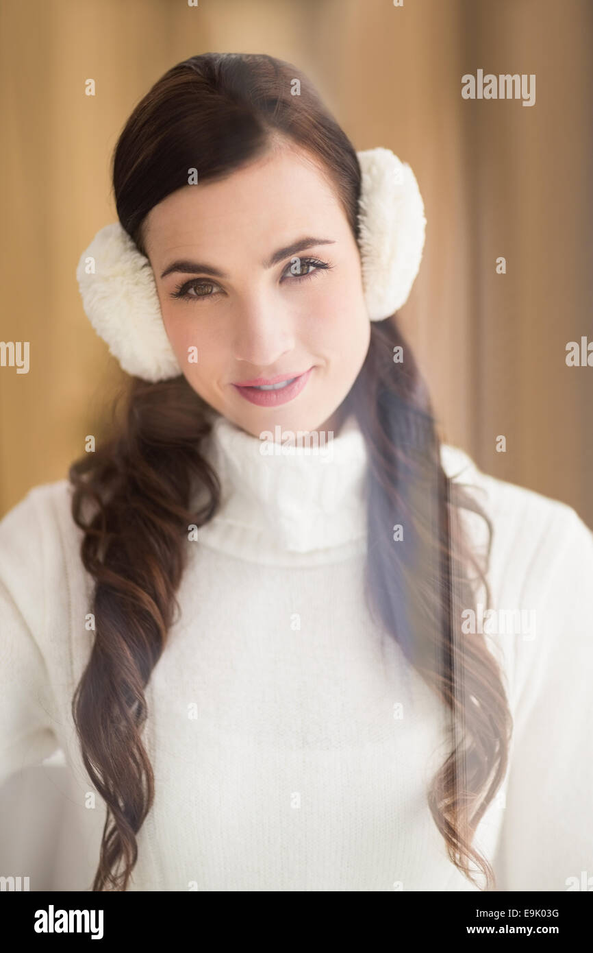 Pretty brunette with ear muffs smiling at camera Stock Photo - Alamy