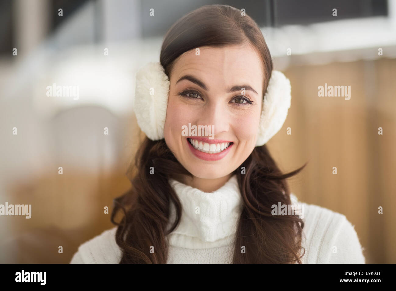 Beauty brunette with ear muffs smiling at camera Stock Photo - Alamy