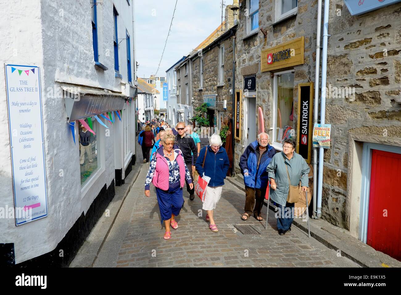 Tourists and visitors walking down Fore street St Ives Cornwall England ...