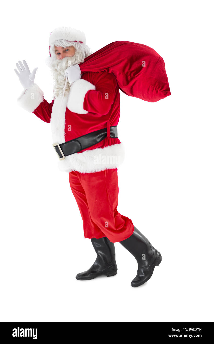 Santa holding a sack and waving Stock Photo - Alamy