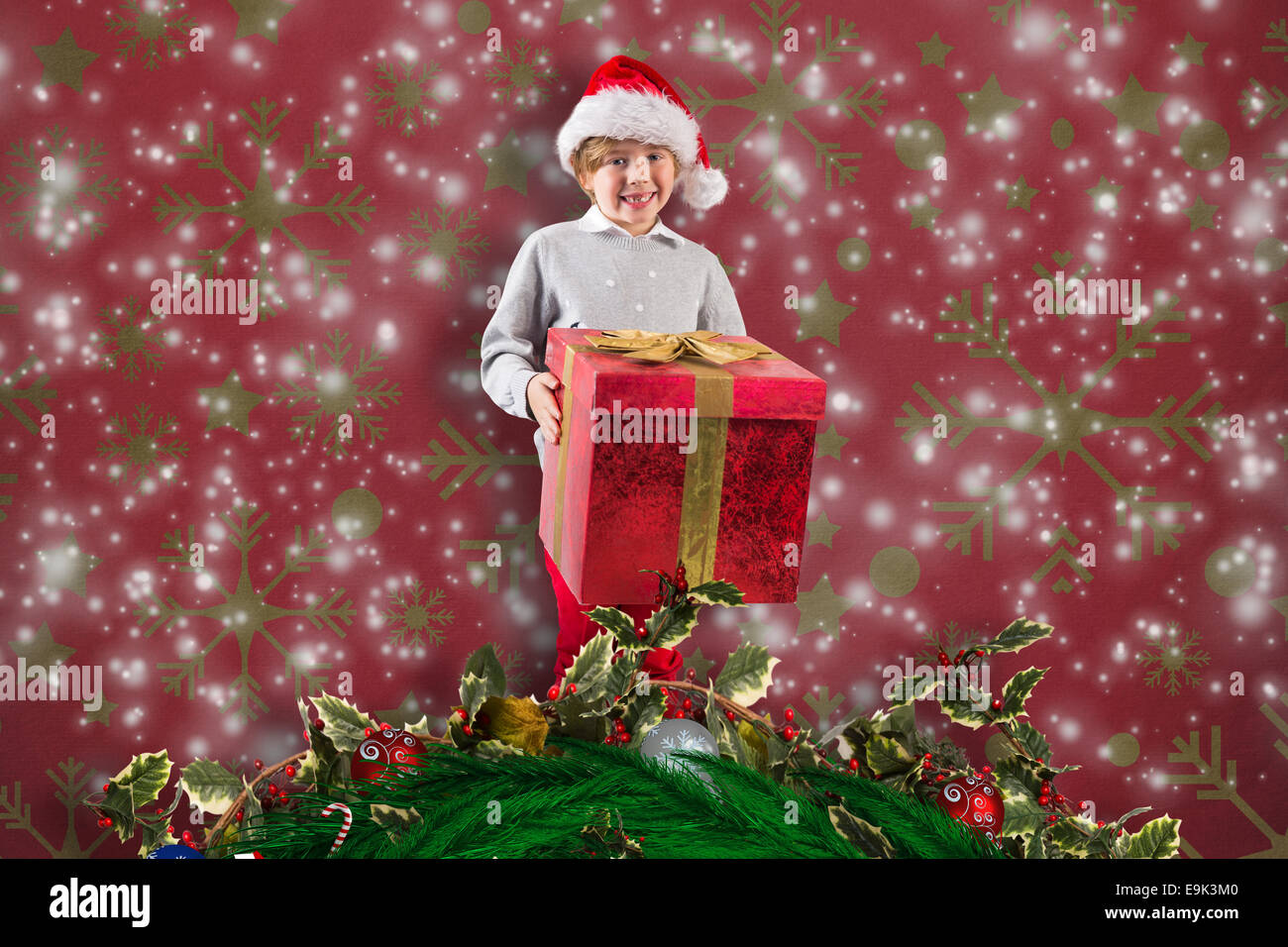 Composite image of festive boy holding gift Stock Photo - Alamy