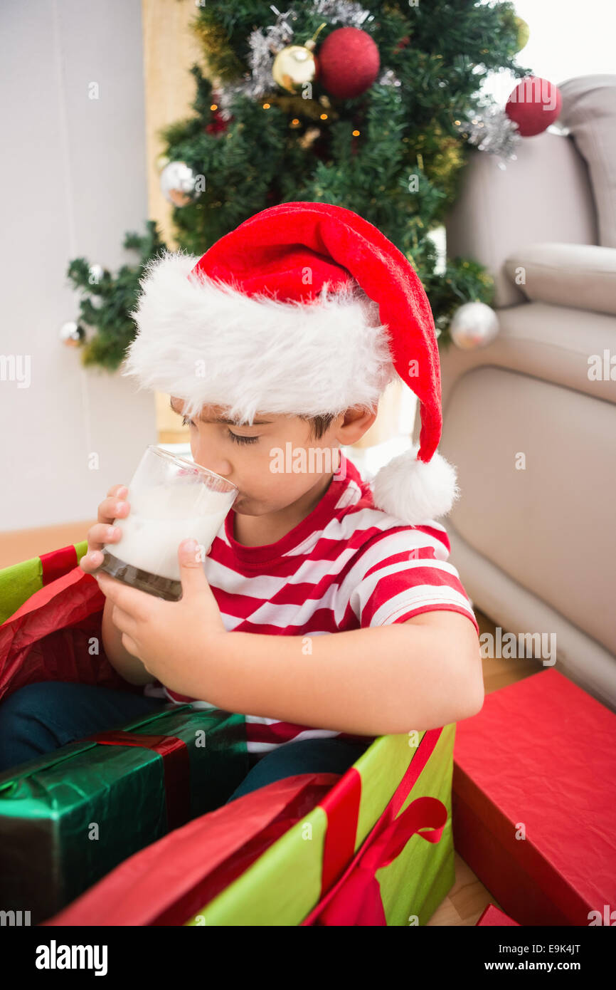 Cute boy in large christmas present drinking milk Stock Photo - Alamy