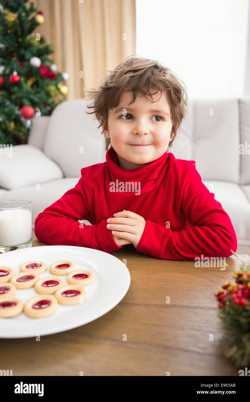 Festive little boy having milk and cookies Stock Photo - Alamy