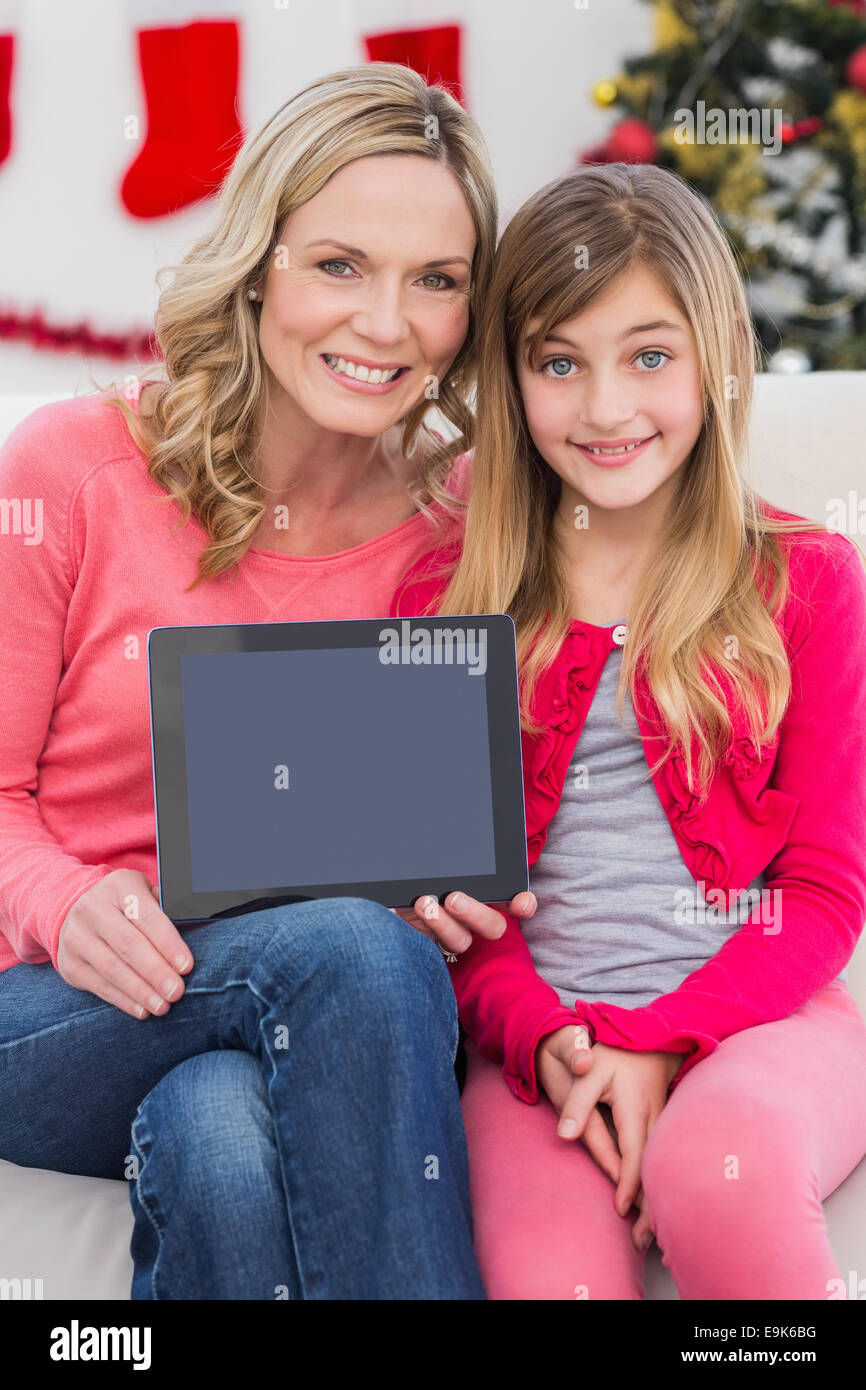 Festive mother and daughter showing tablet screen Stock Photo - Alamy