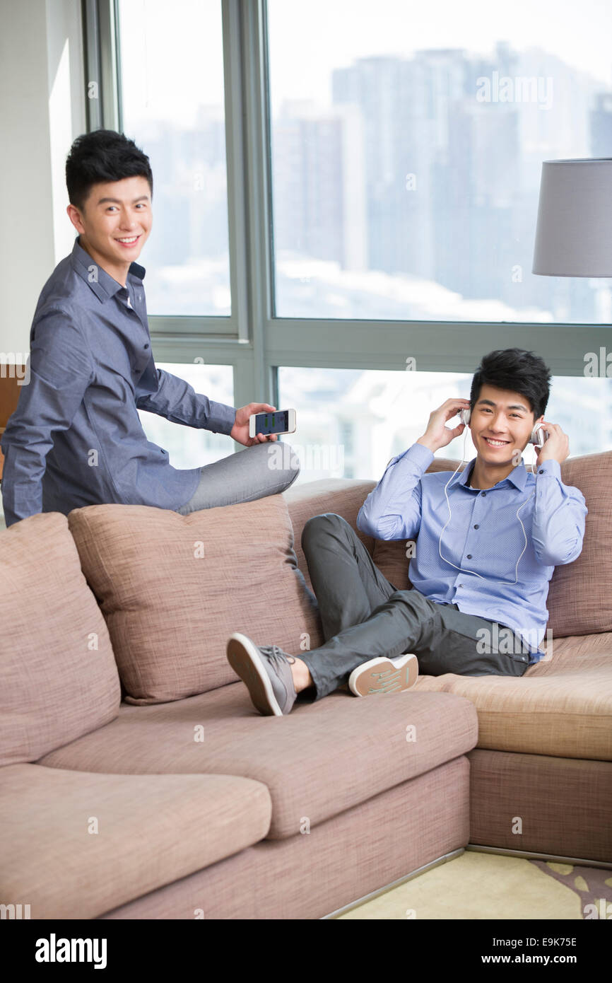 Happy young men in living room Stock Photo - Alamy