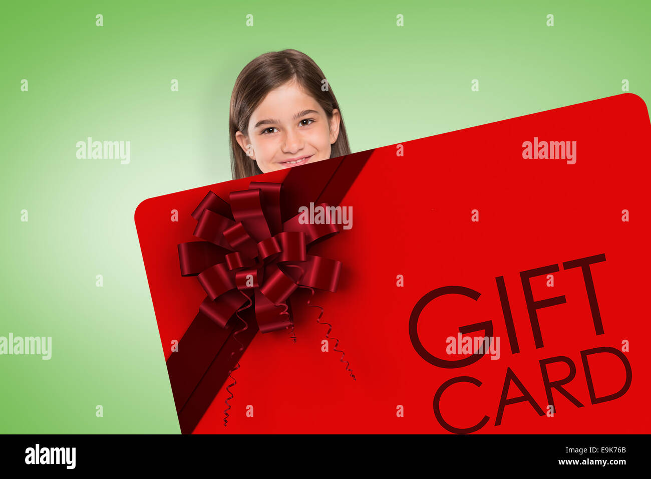Composite image of cute little girl showing card Stock Photo - Alamy