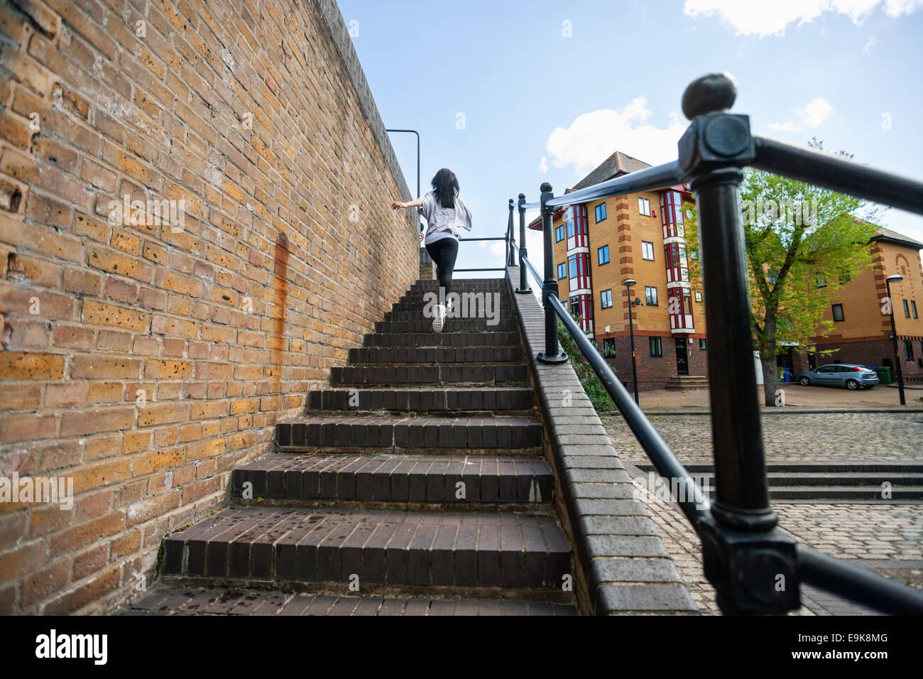 Full length rear view of young woman walking up stairs outdoors Stock ...
