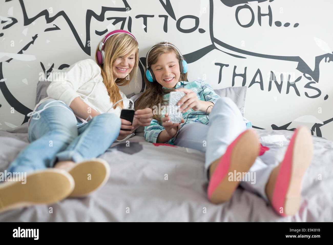 Relaxed sisters listening to music at home Stock Photo - Alamy