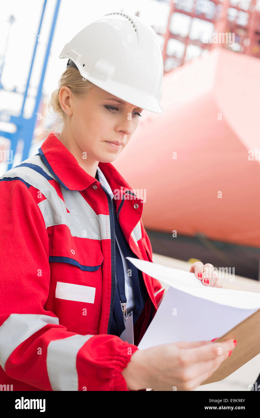 Female engineer reading documents in shipping yard Stock Photo - Alamy