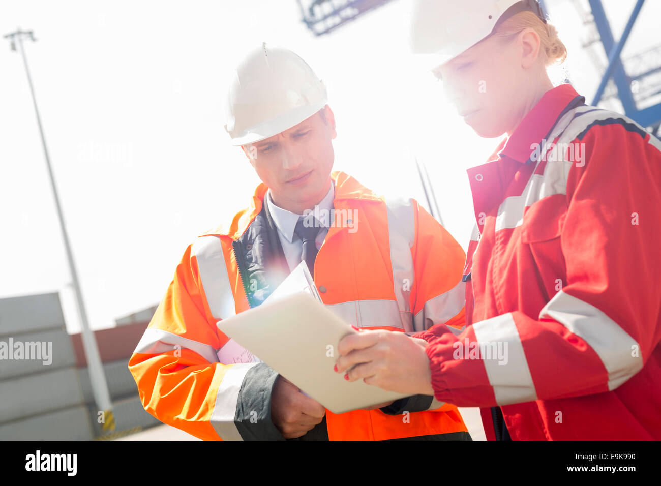 Workers discussing over tablet computer in shipping yard Stock Photo ...