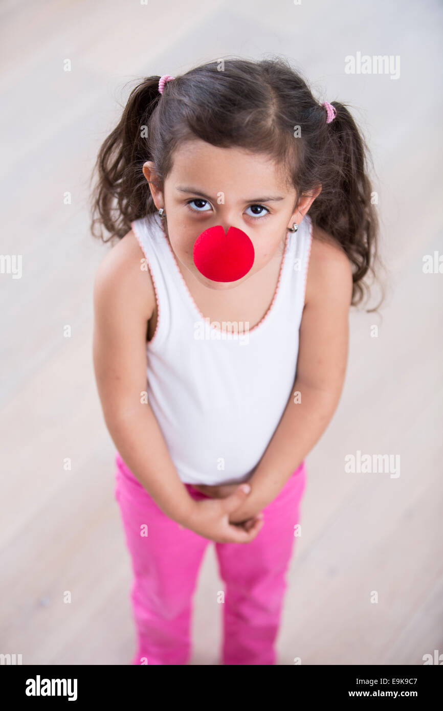 Portrait of cute little girl wearing clown nose at home Stock Photo - Alamy