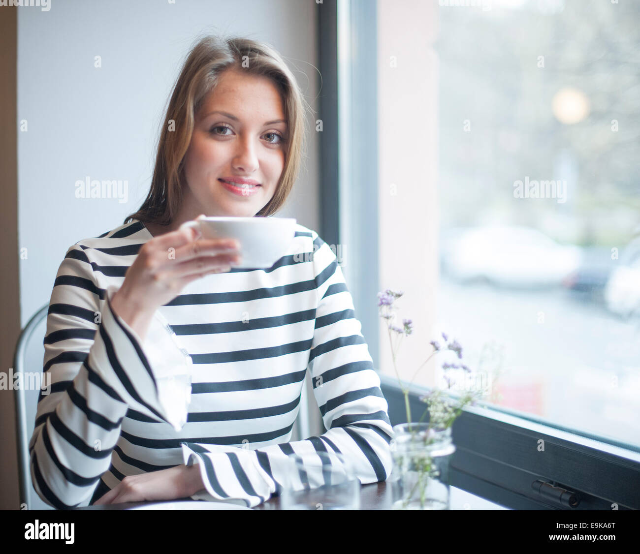 Portrait of smiling woman having coffee at cafe table Stock Photo - Alamy