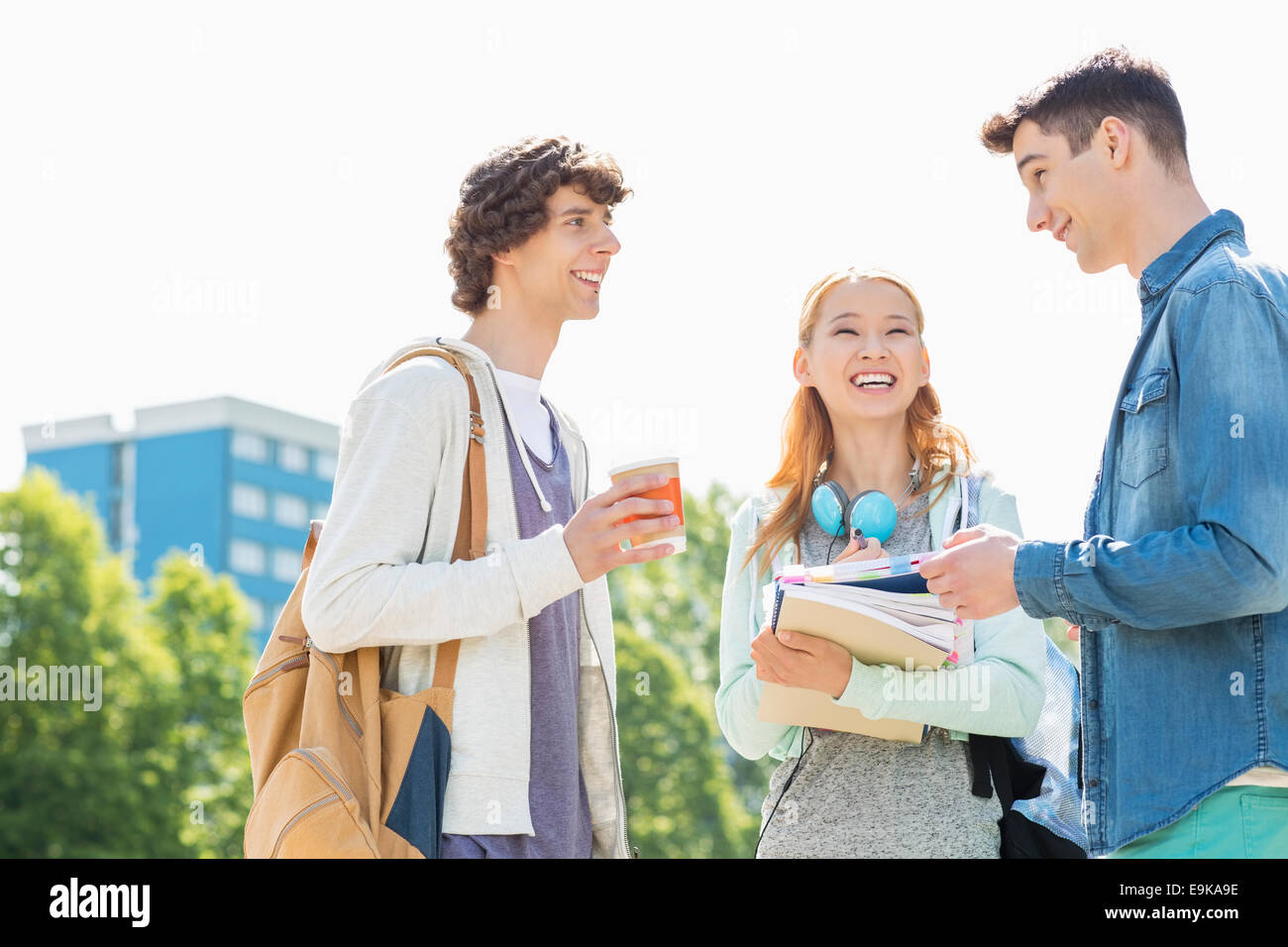 Happy university students conversing at campus Stock Photo - Alamy