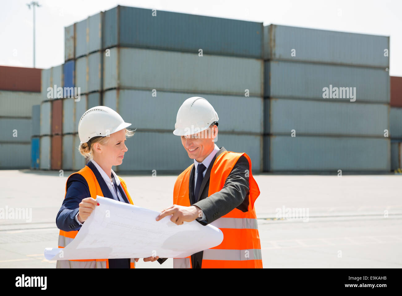 Engineers looking at blueprint in shipping yard Stock Photo - Alamy