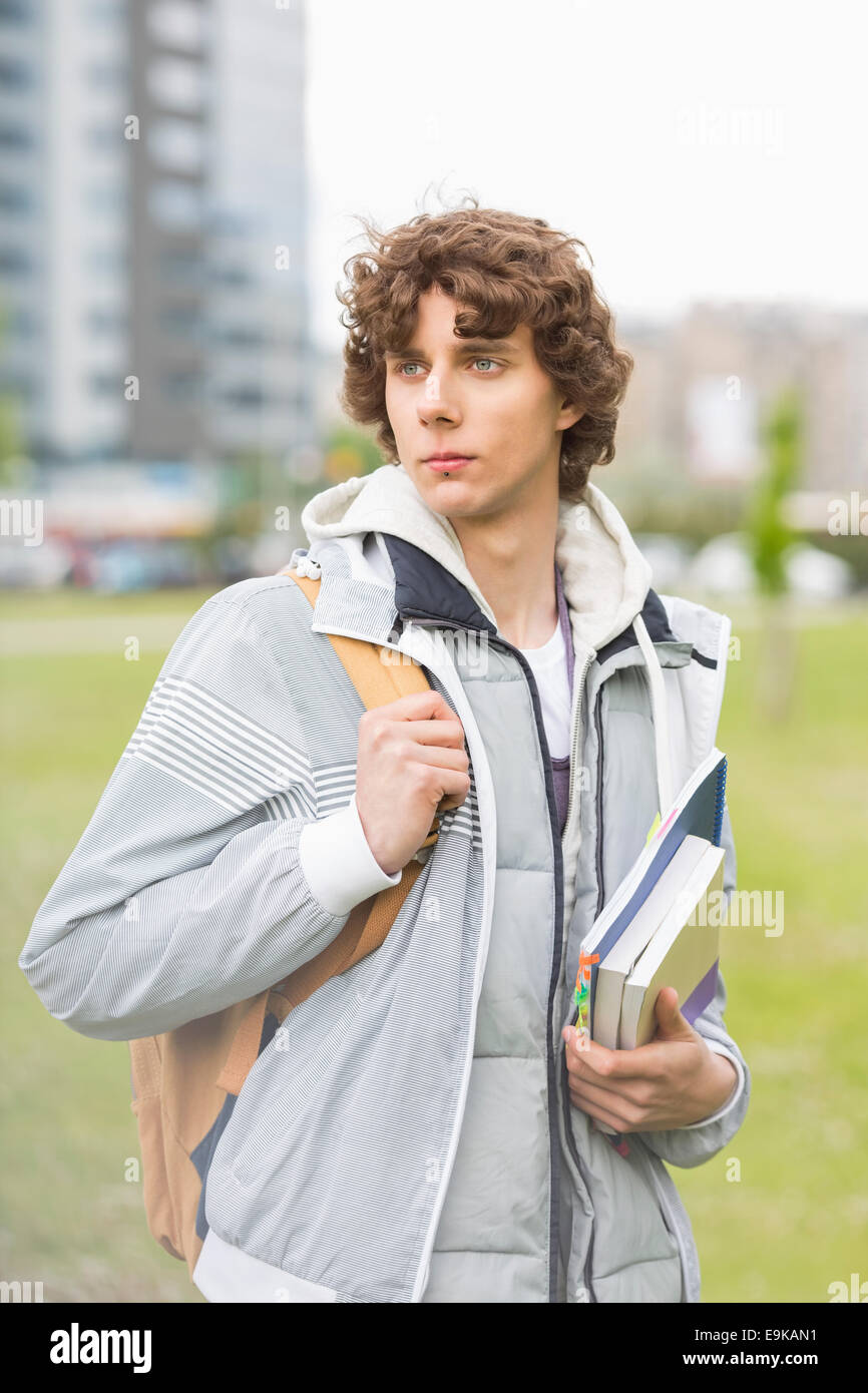 Young male university student holding textbooks at campus Stock Photo ... Young male university student holding textbooks at campus Stock Photo ...