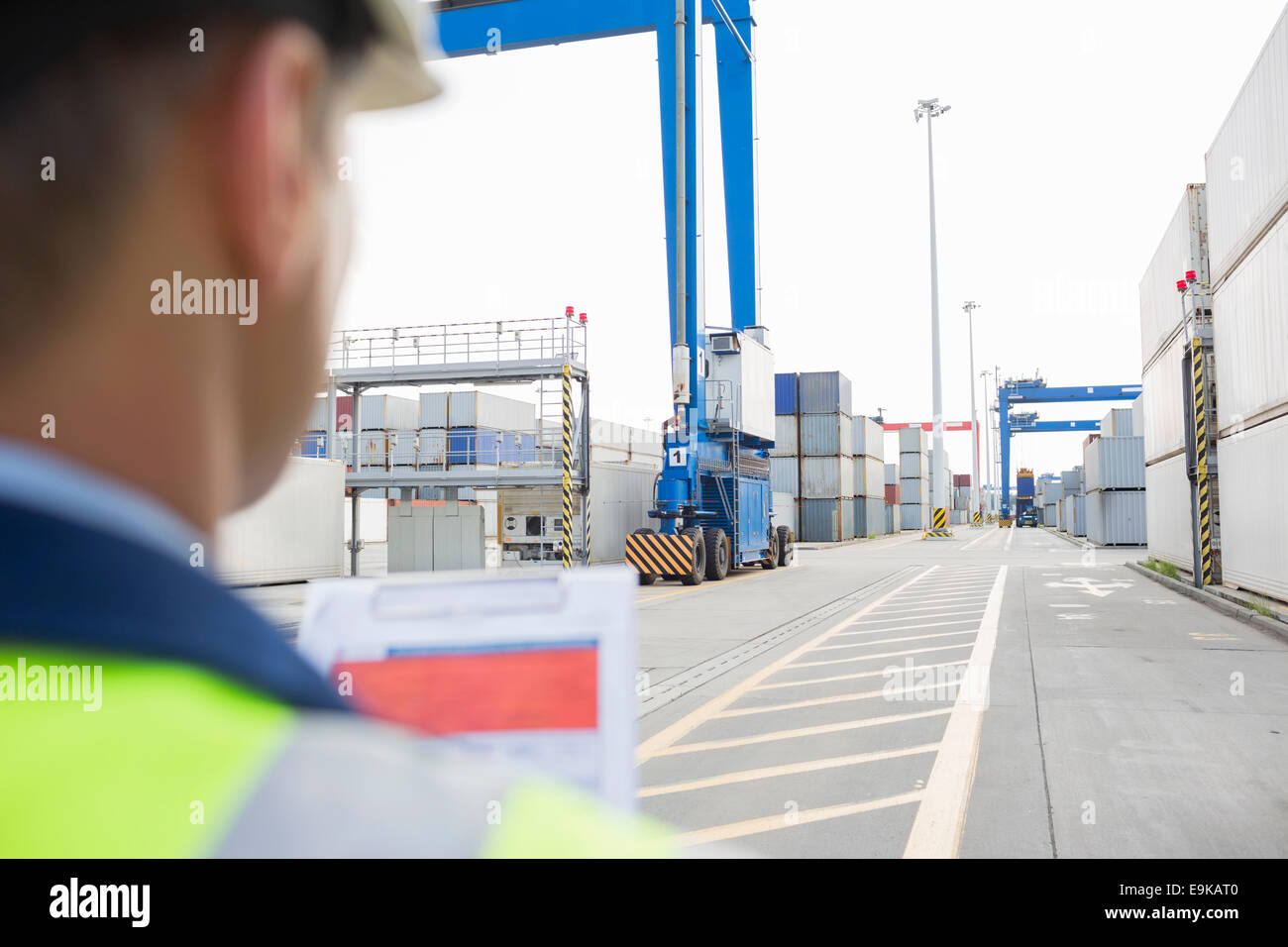 Male supervisor with clipboard in shipping yard Stock Photo - Alamy