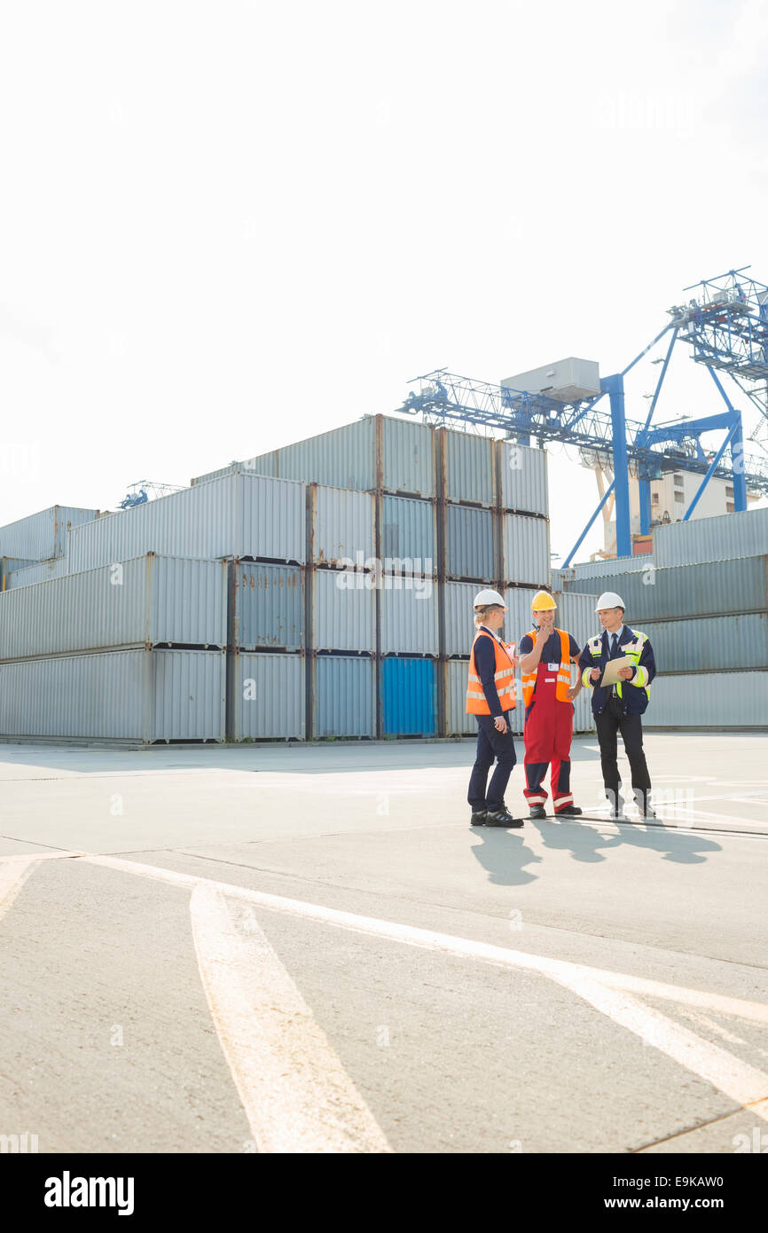 Full-length of workers talking in shipping yard Stock Photo - Alamy