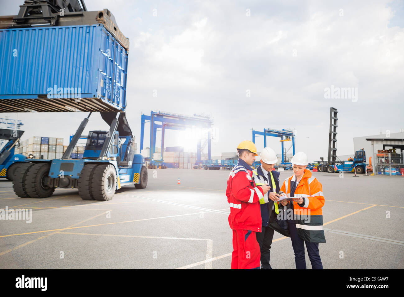 Workers discussing in shipping yard Stock Photo - Alamy