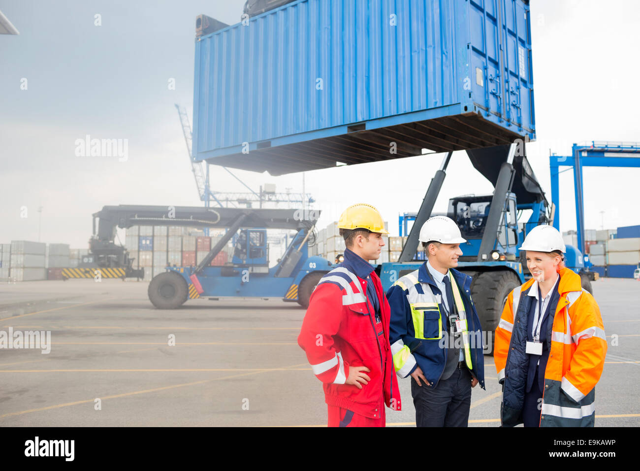 Workers discussing in shipping yard Stock Photo - Alamy