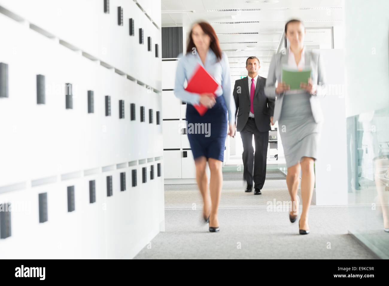 Blurred view of businesswomen walking in office Stock Photo - Alamy