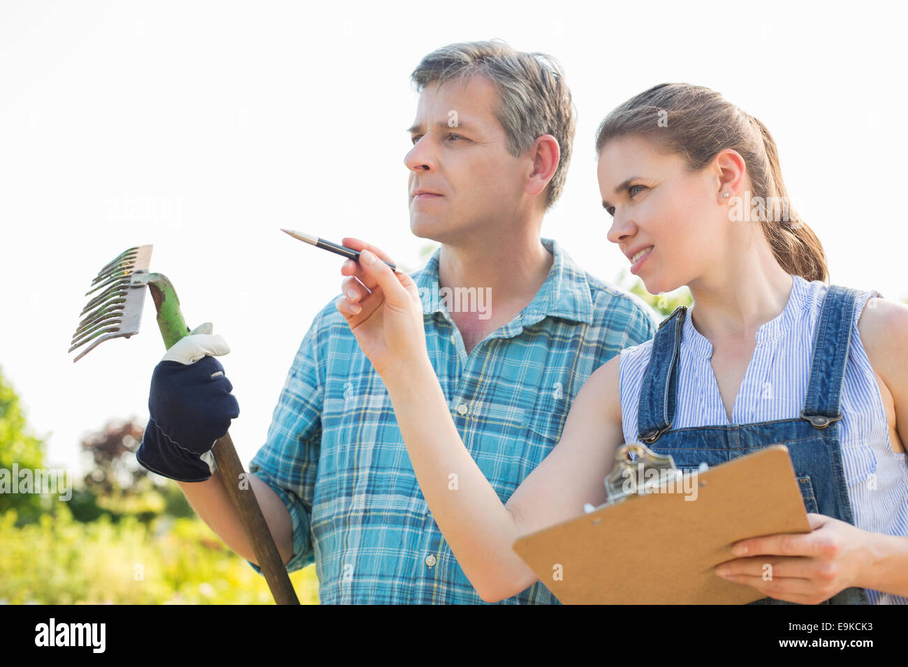 Female supervisor explaining something to gardener at plant nursery ...