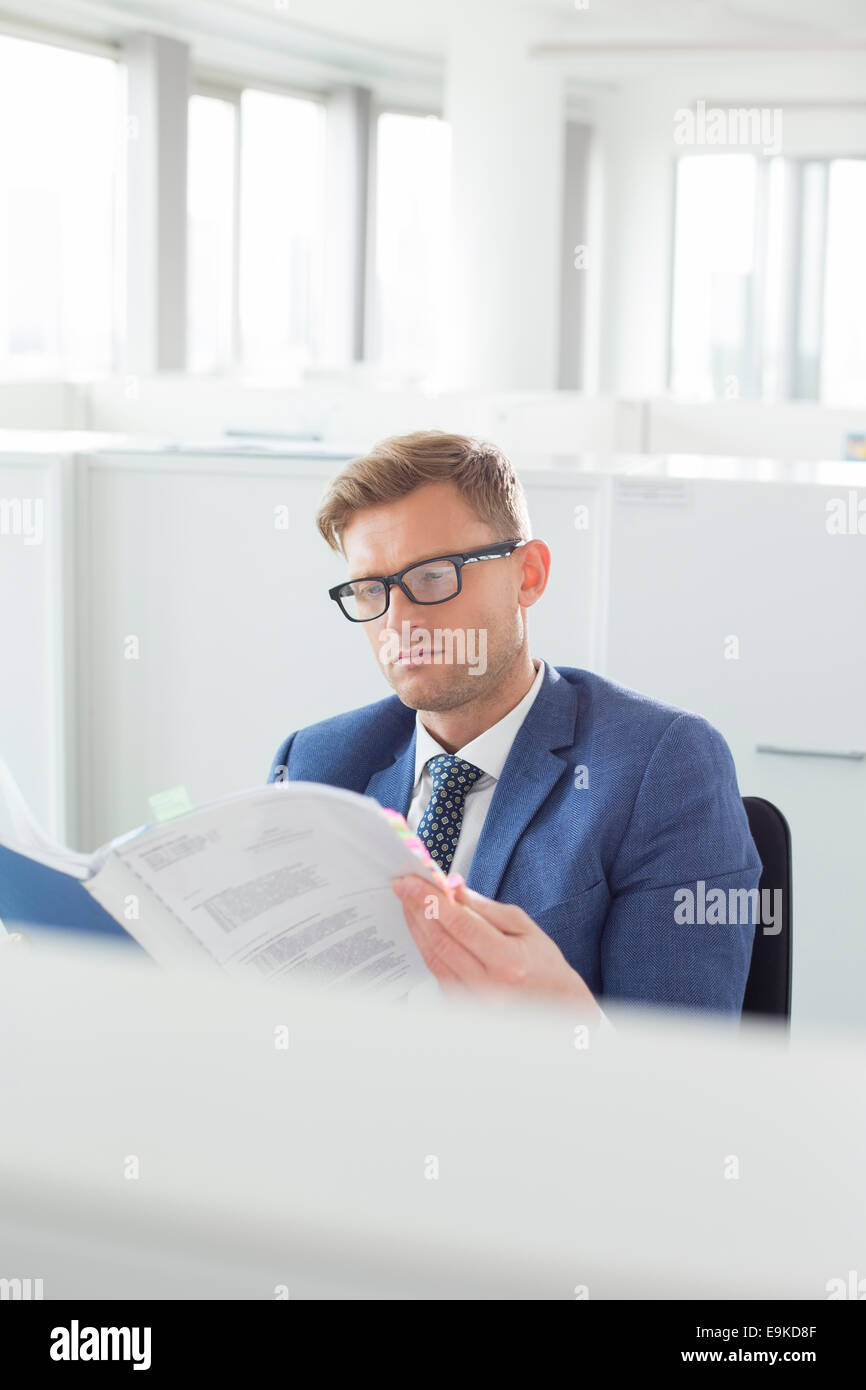 Businessman reading file in creative office Stock Photo - Alamy