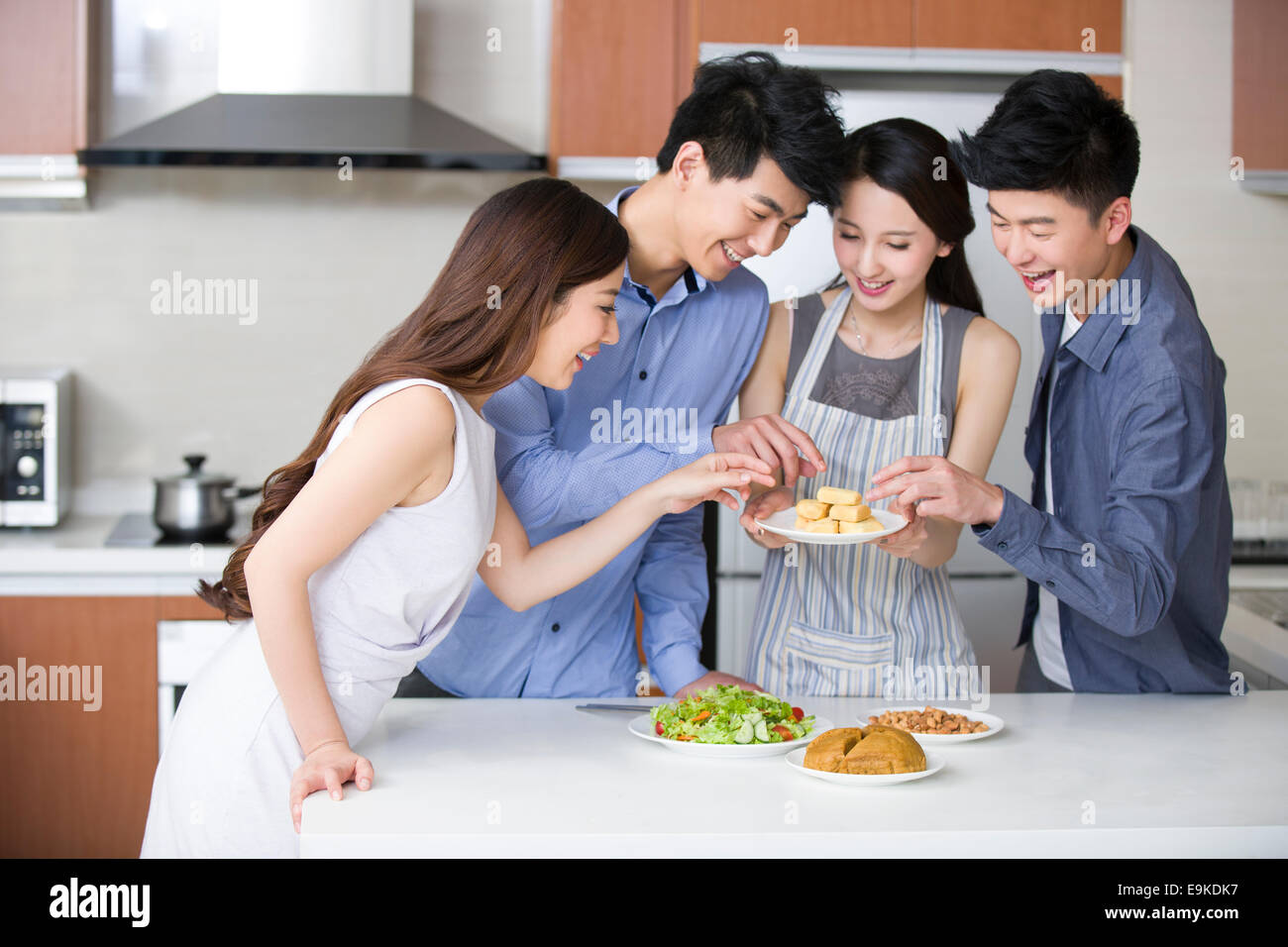 Young woman cooking for her friends in the kitchen Stock Photo - Alamy