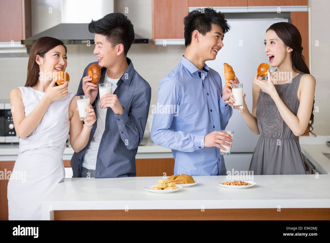 Happy young friends eating breakfast in the kitchen Stock Photo - Alamy