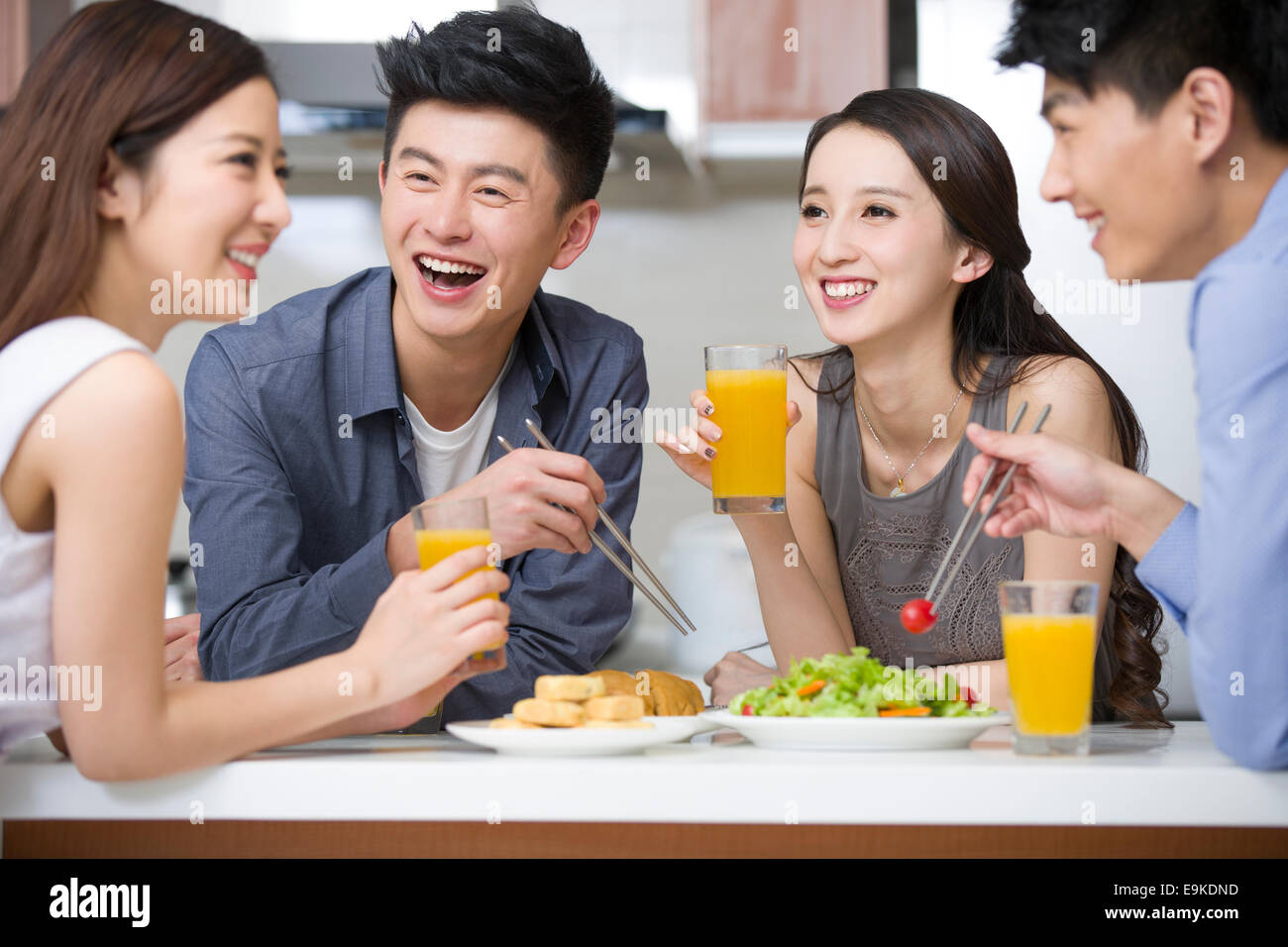 Happy friends eating together Stock Photo - Alamy