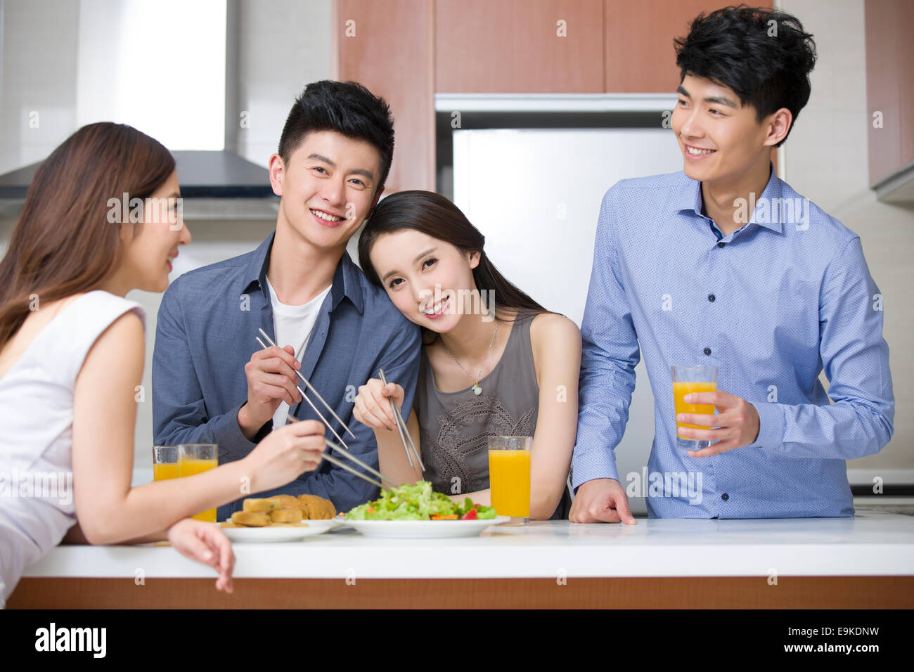 Happy friends eating together Stock Photo - Alamy