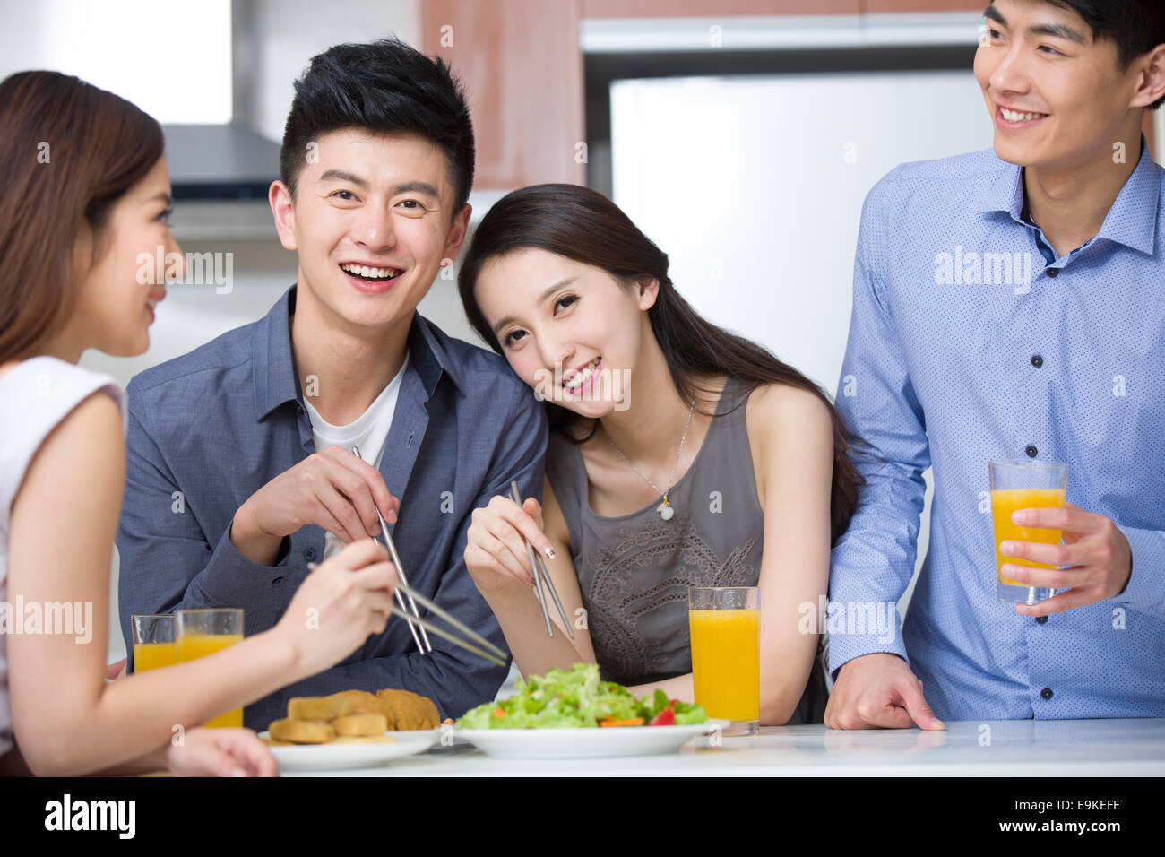 Happy friends eating together Stock Photo - Alamy