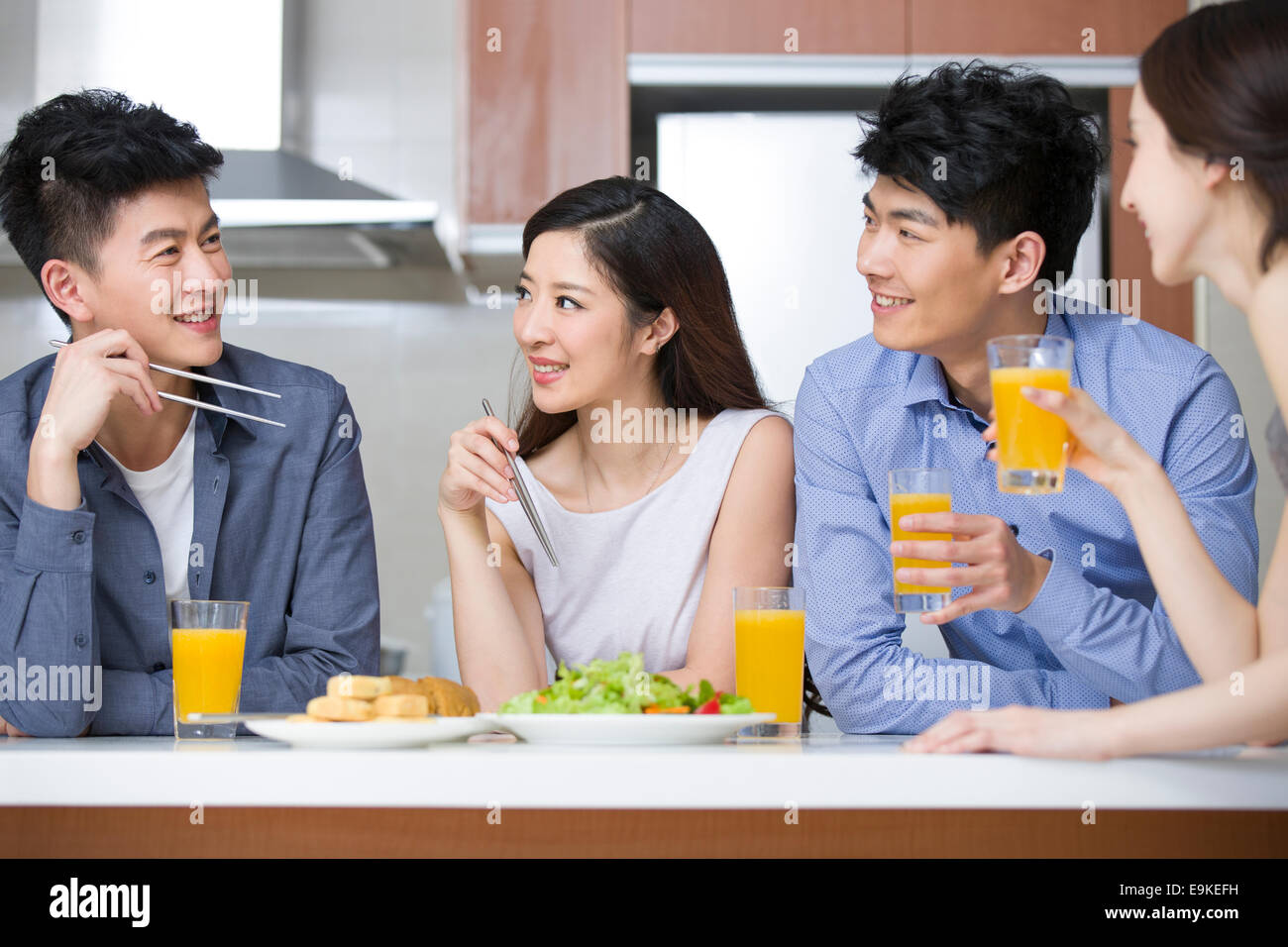 Happy friends eating together Stock Photo - Alamy
