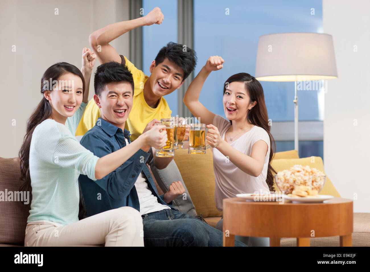 Cheerful young adults toasting with beer Stock Photo - Alamy