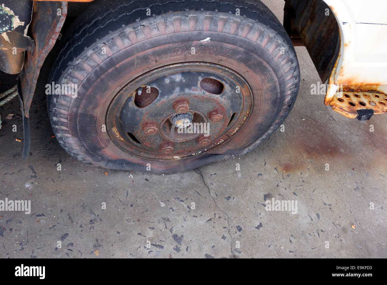 Flat tyre on old rusty vehicle Stock Photo - Alamy