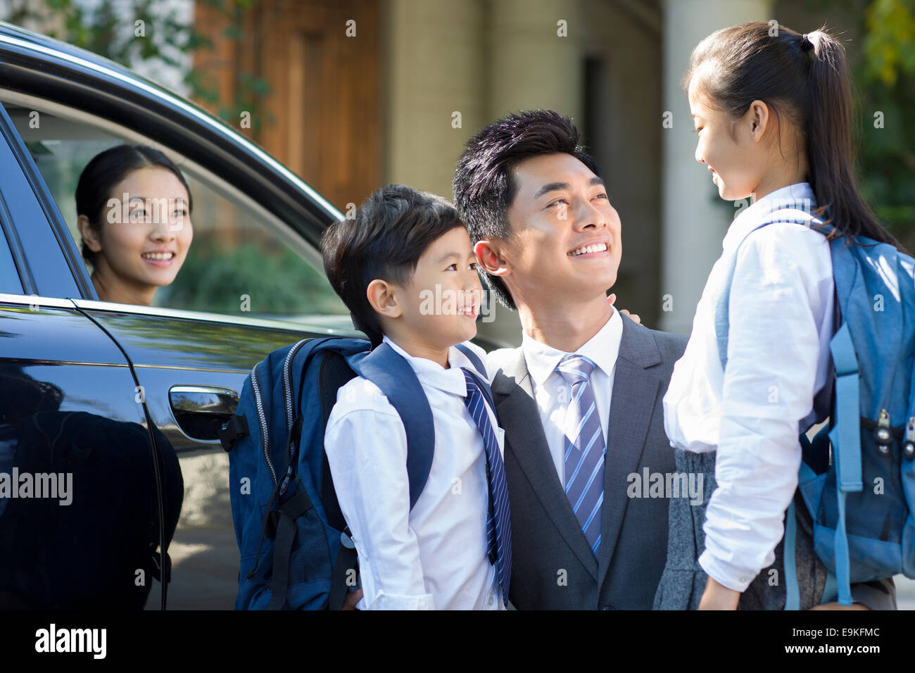 Young couple sending their children to school Stock Photo - Alamy