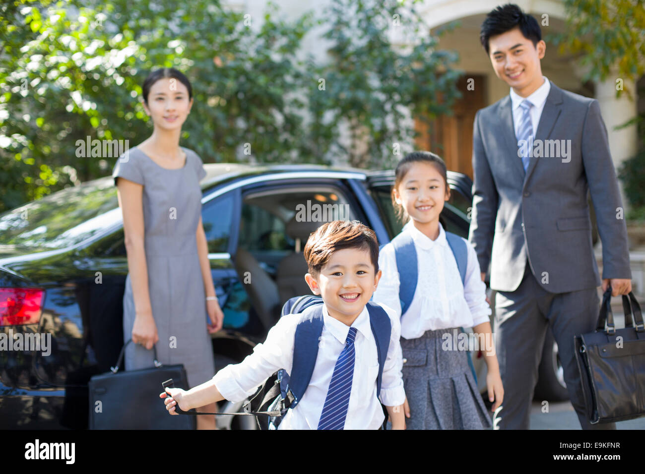 Young couple bringing their children back from school Stock Photo - Alamy