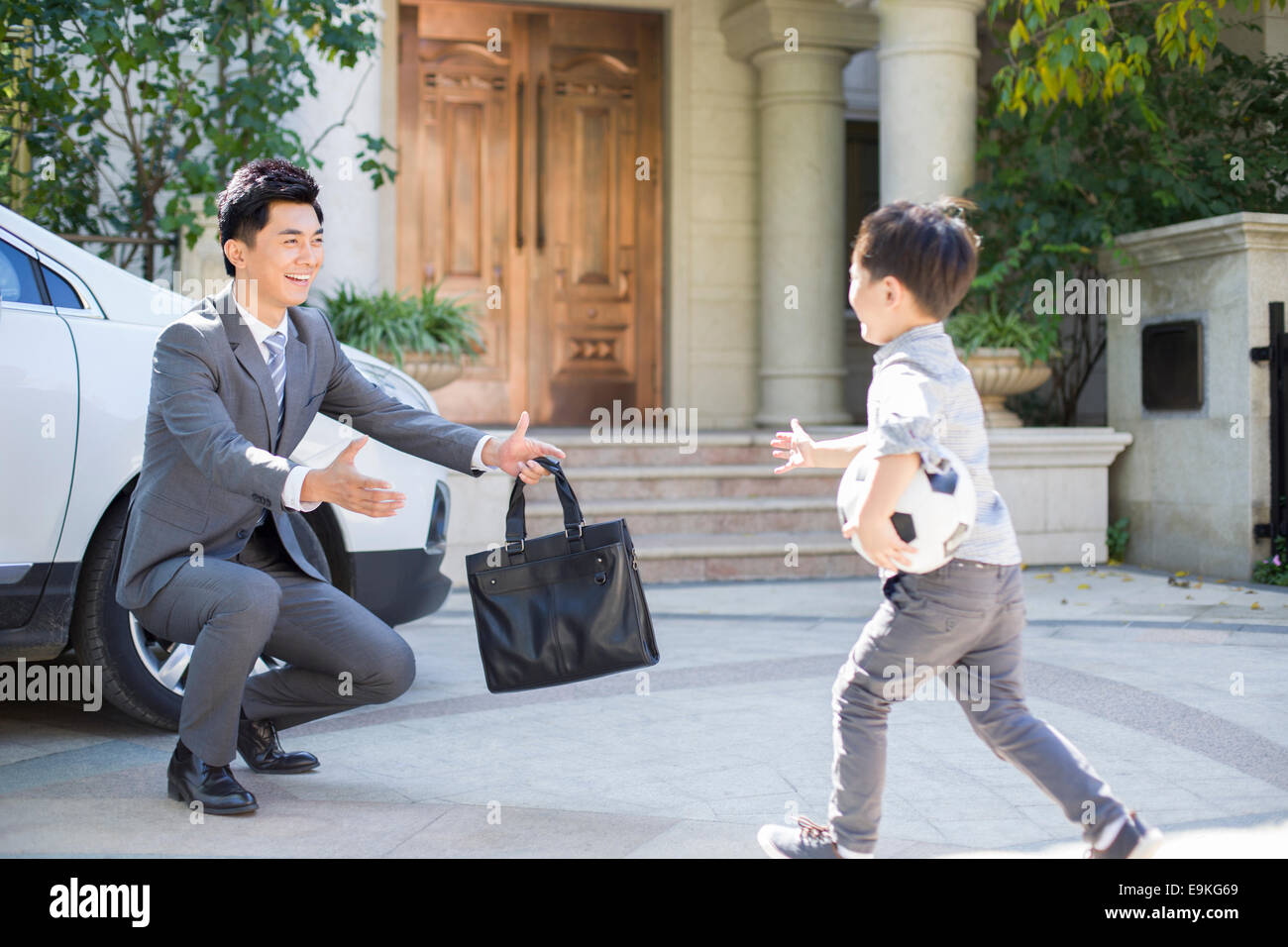 Little boy with football running towards to his father Stock Photo - Alamy