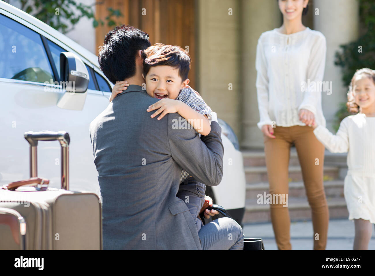 Son greeting returning father Stock Photo - Alamy