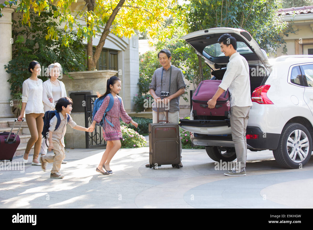 Happy family packing for car trip Stock Photo - Alamy