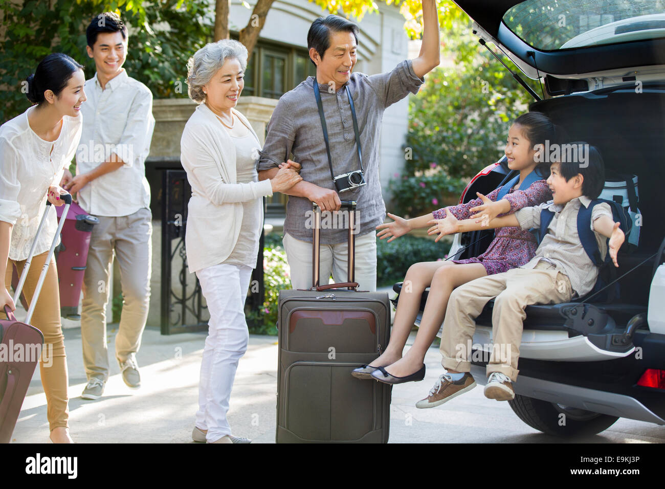 Happy family packing for car trip Stock Photo - Alamy