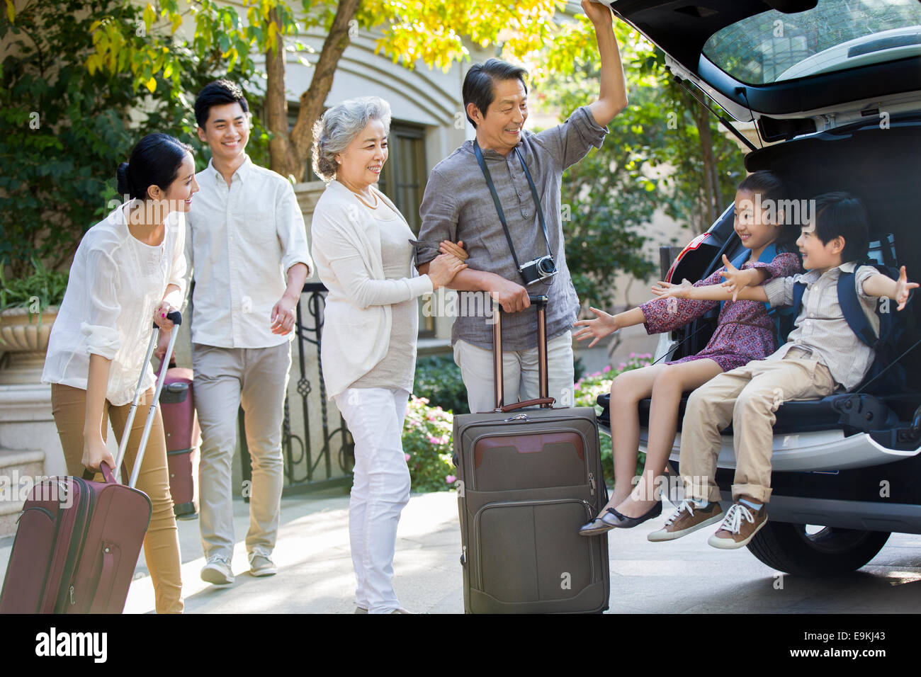 Happy family packing for car trip Stock Photo - Alamy